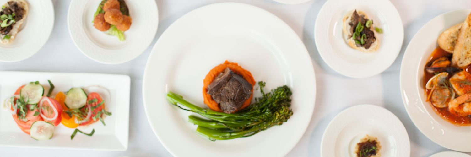 A variety of dishes prepared on multiple white plates.